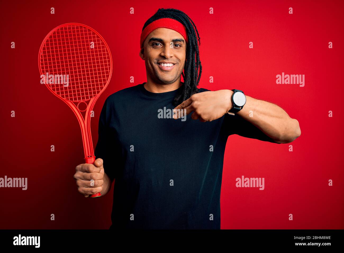 African american afro sportsman with dreadlocks holding tennis racket ...