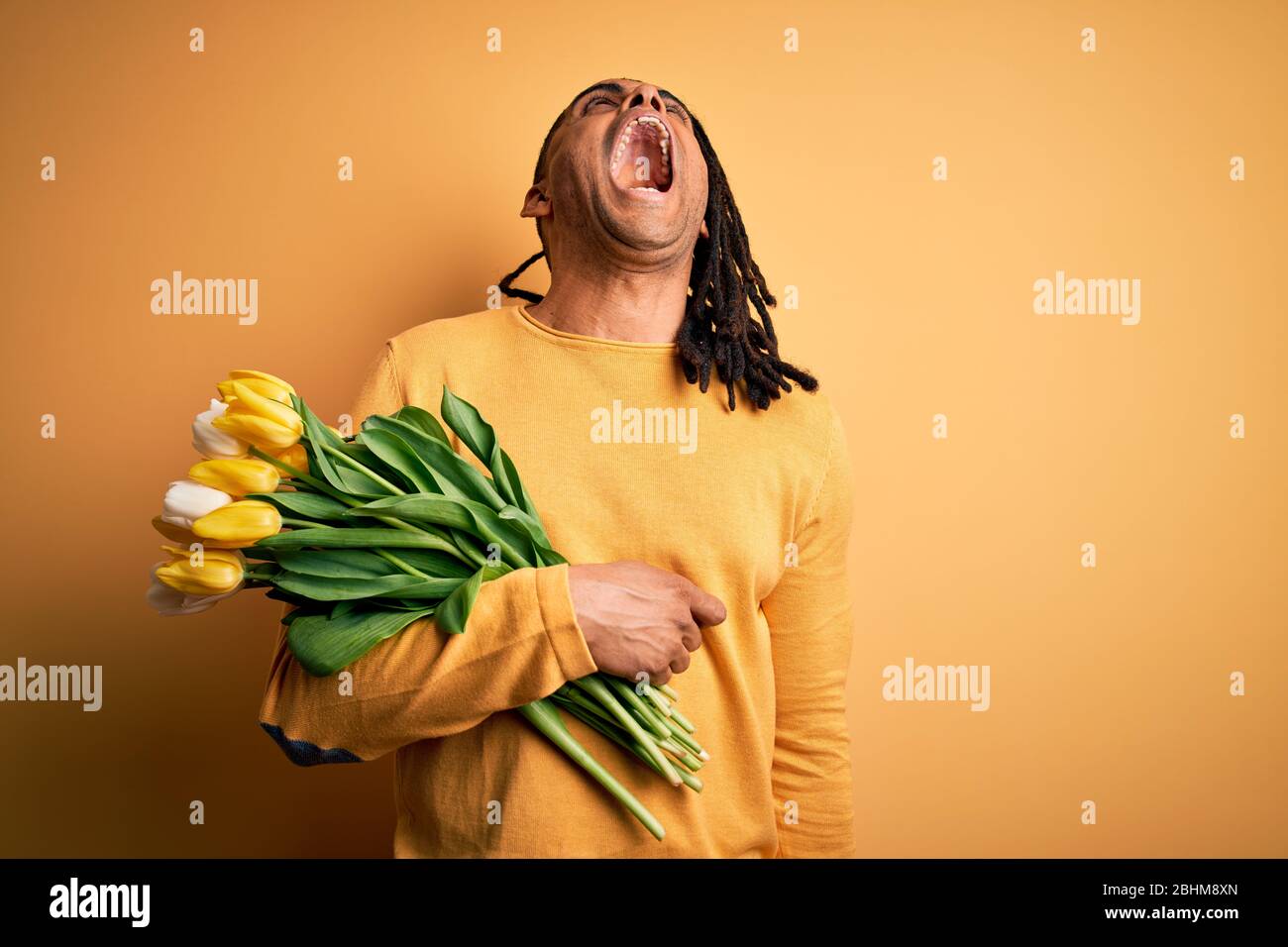 Young african american afro romantic man with dreadlocks holding ...
