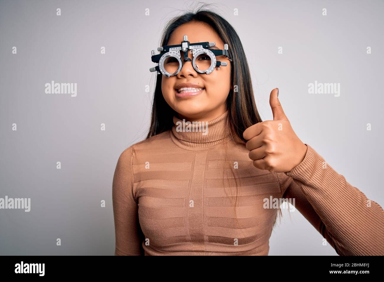 Young asian optical girl controlling eyesight using optometry glasses ...