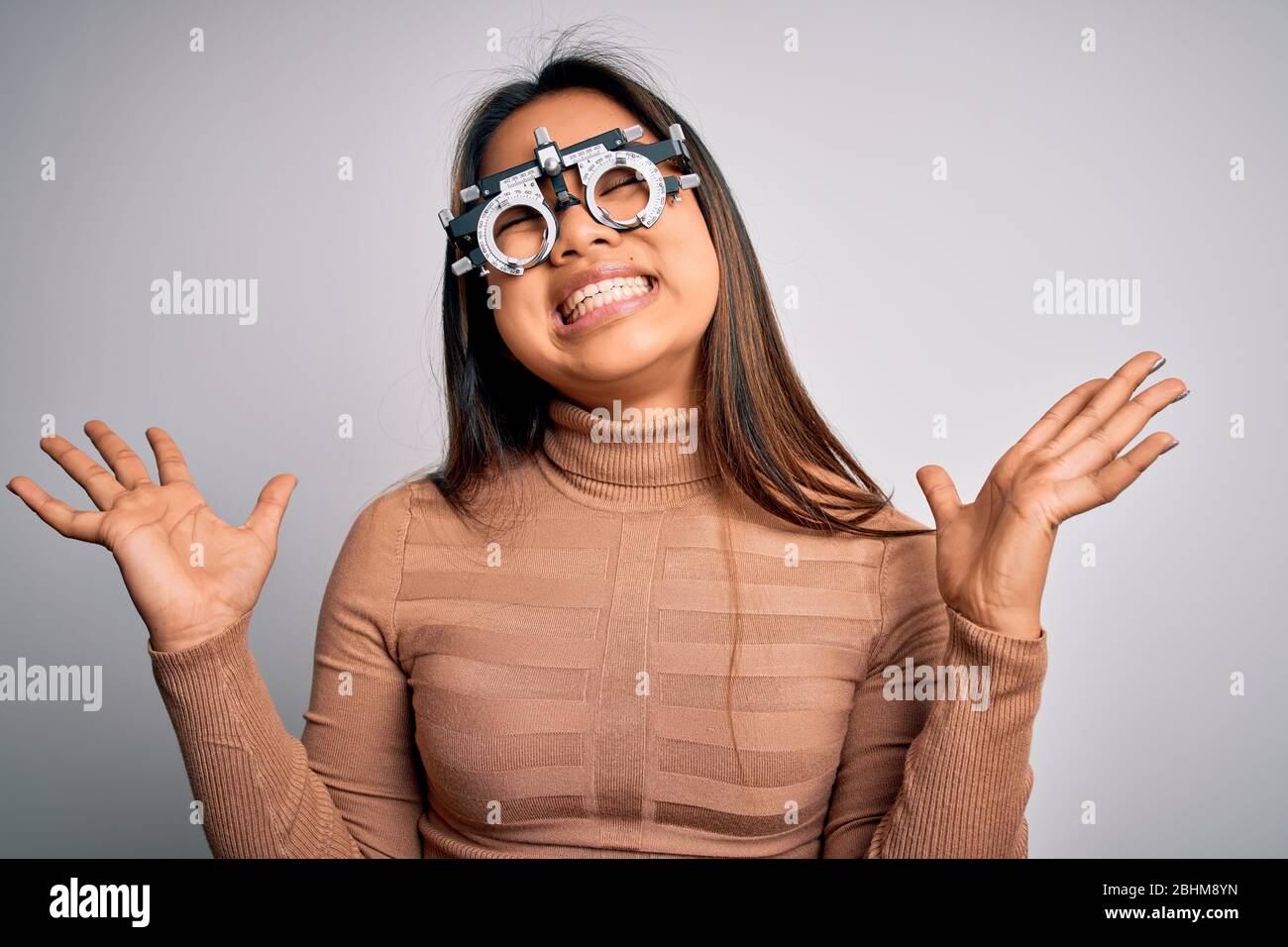 Young asian optical girl controlling eyesight using optometry glasses ...