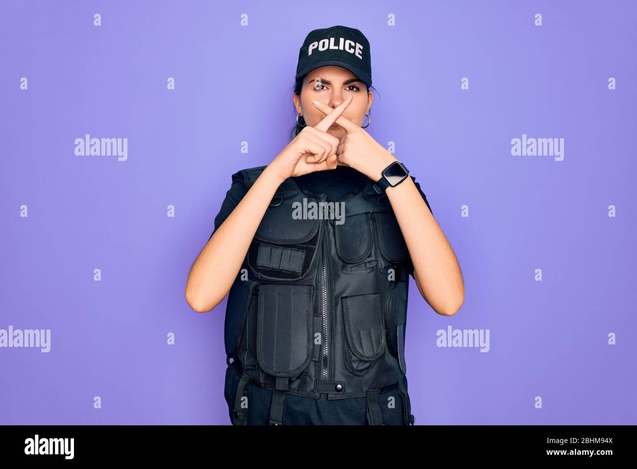 Young police woman wearing security bulletproof vest uniform over ...