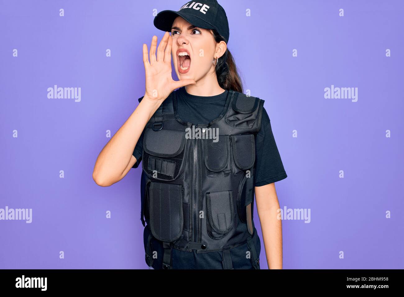 Young police woman wearing security bulletproof vest uniform over ...