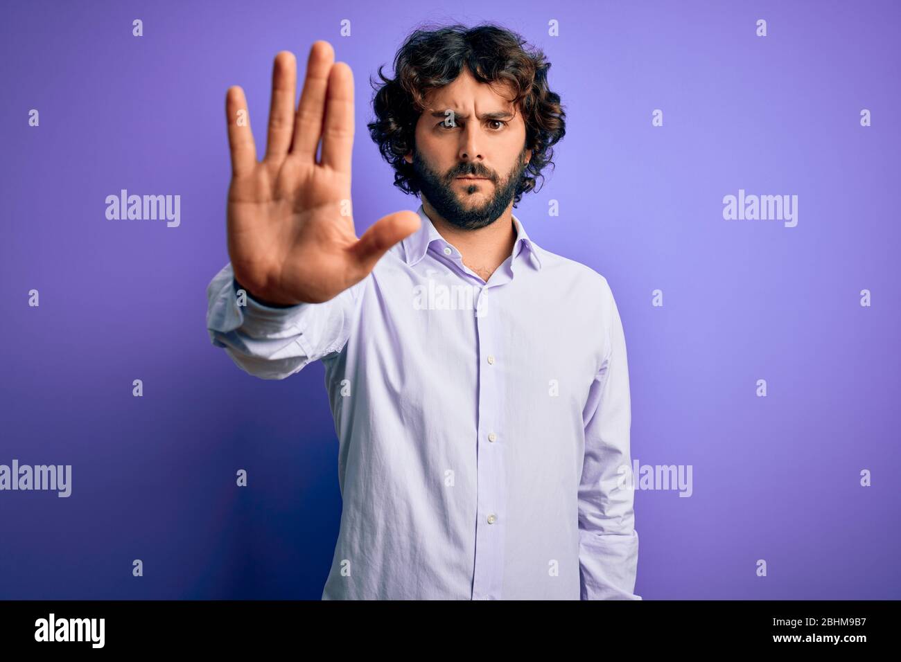 Young handsome business man with beard wearing shirt standing over ...