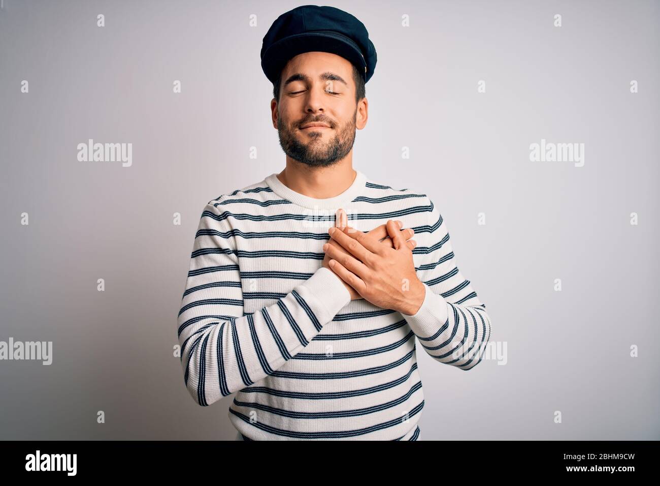 Young handsome sailor man with beard wearing navy striped uniform and ...
