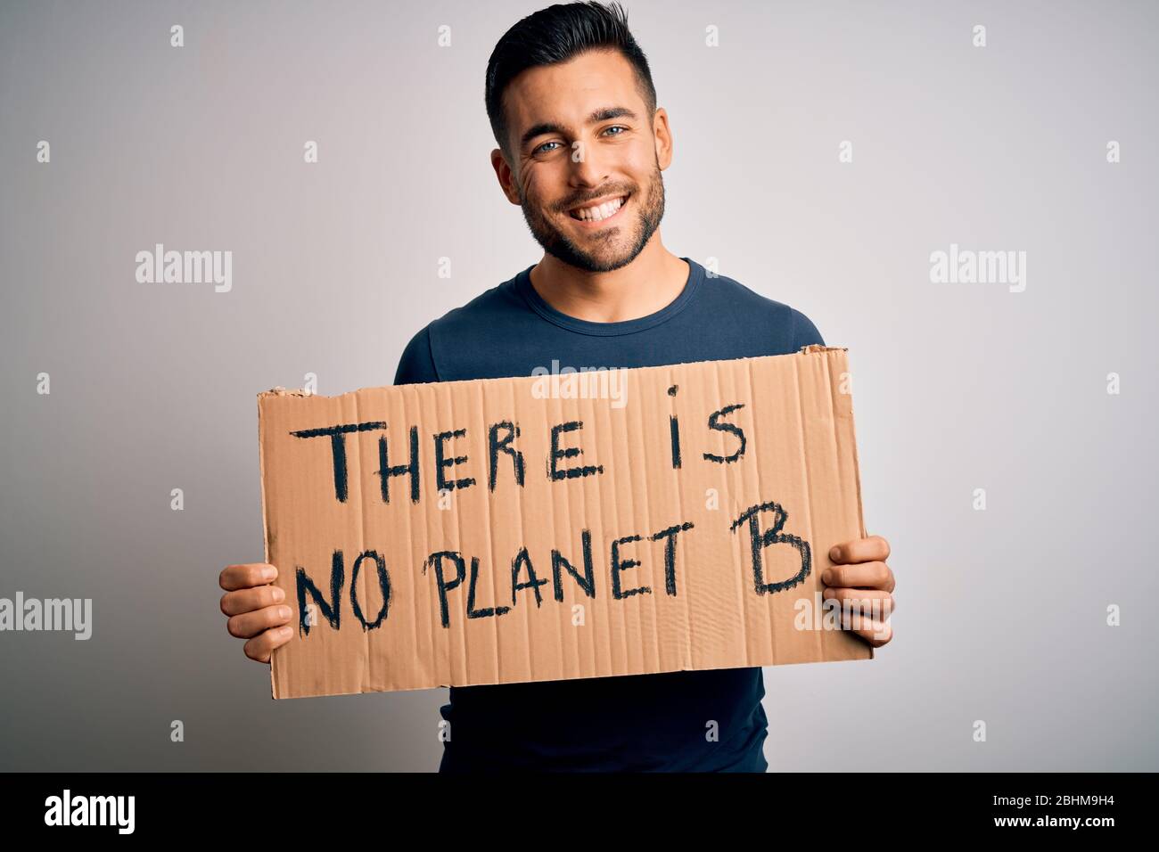 Young handsome activist man protesting for the enviroment hoding ...