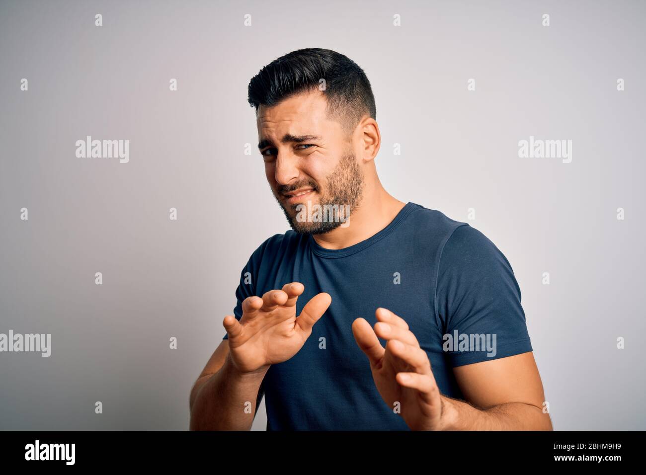 Young handsome man wearing casual t-shirt standing over isolated white ...