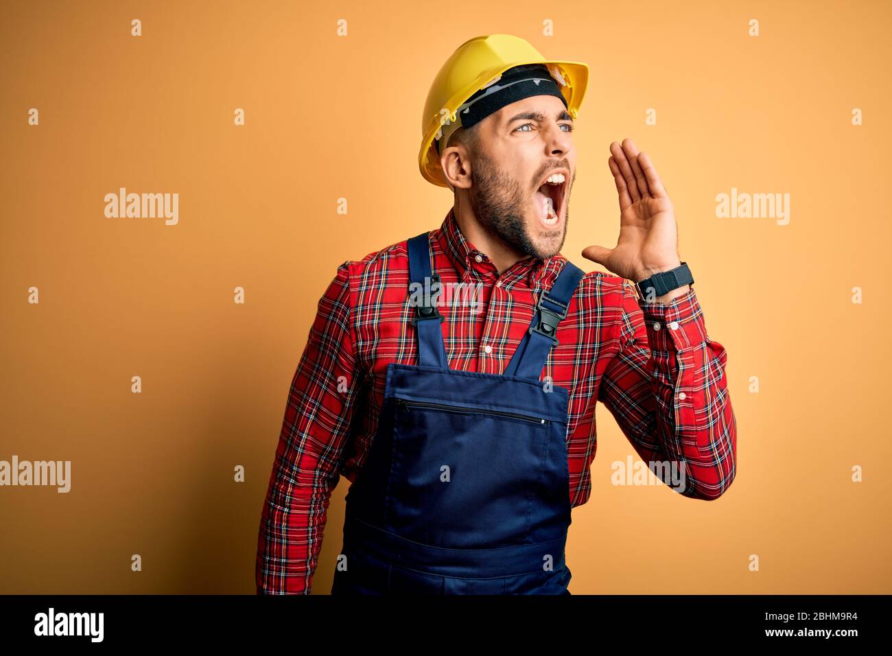 Young builder man wearing construction uniform and safety helmet over ...
