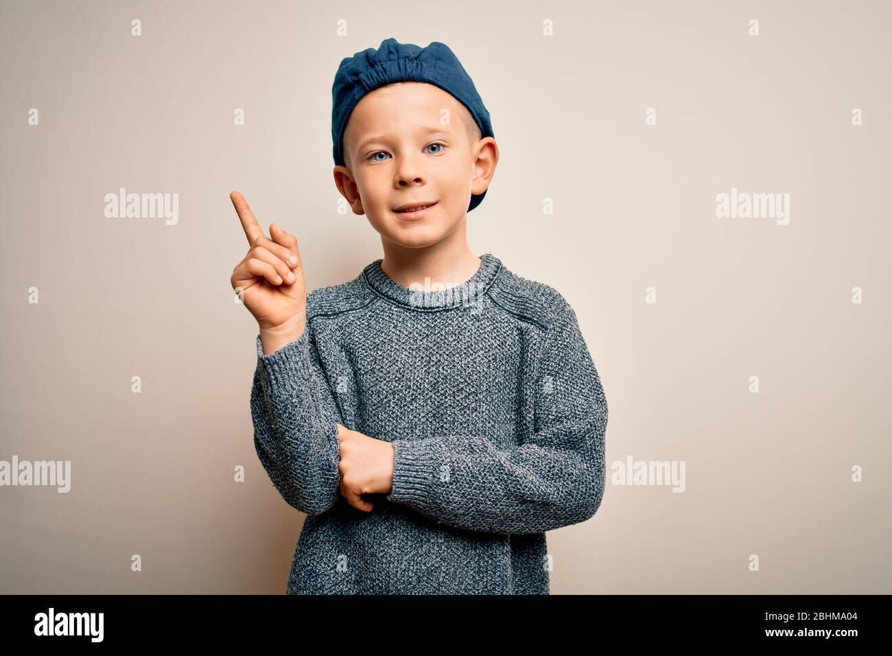 Young little caucasian kid with blue eyes wearing wool cap over ...