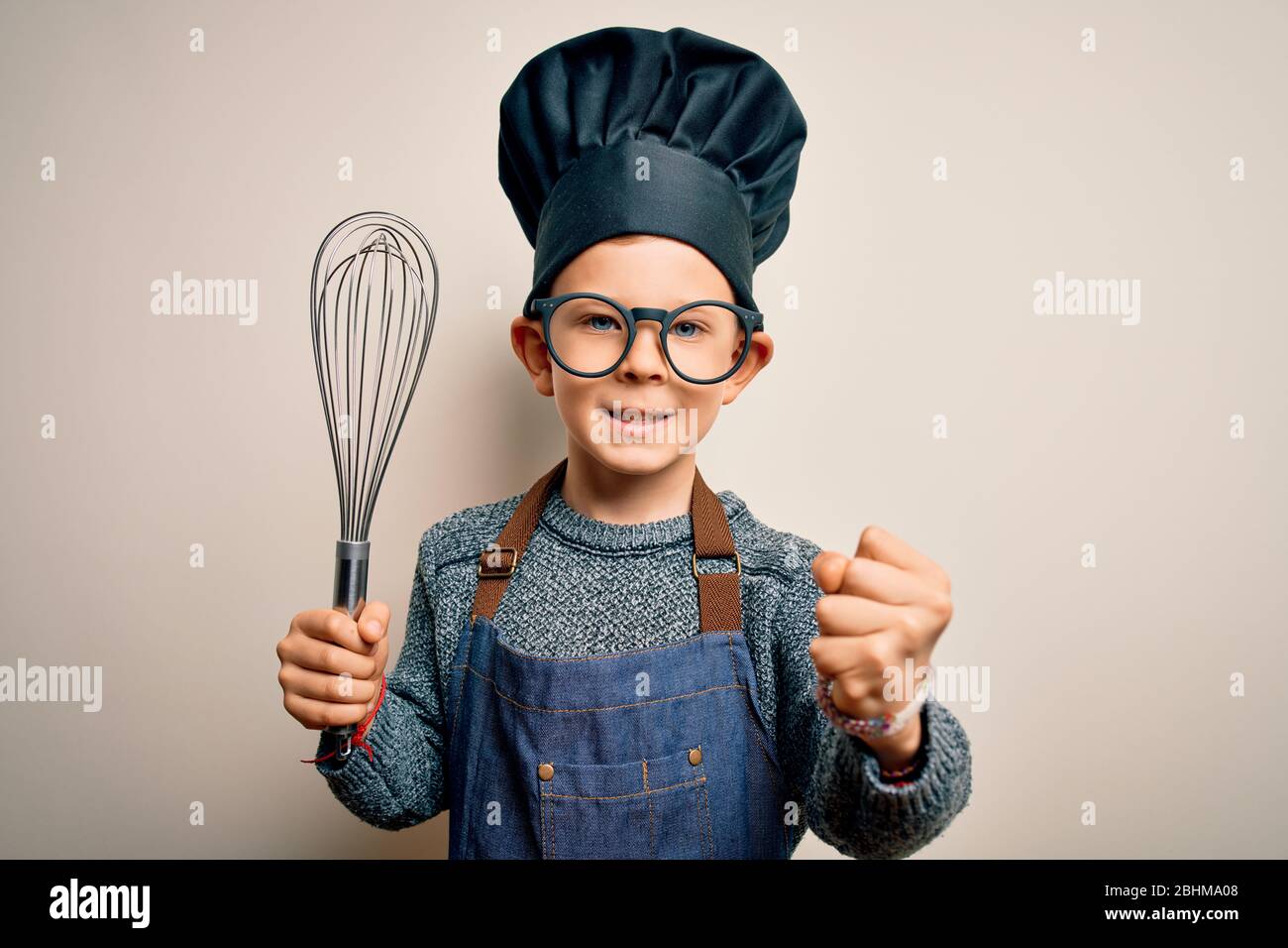 Young little caucasian cook kid wearing chef uniform and hat using ...