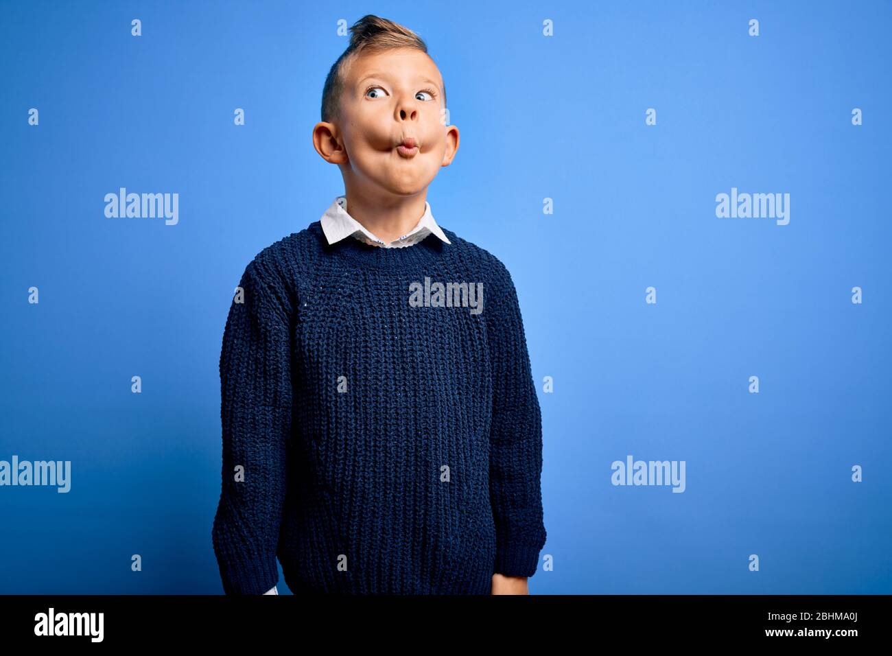 Young little caucasian kid with blue eyes wearing winter sweater over ...