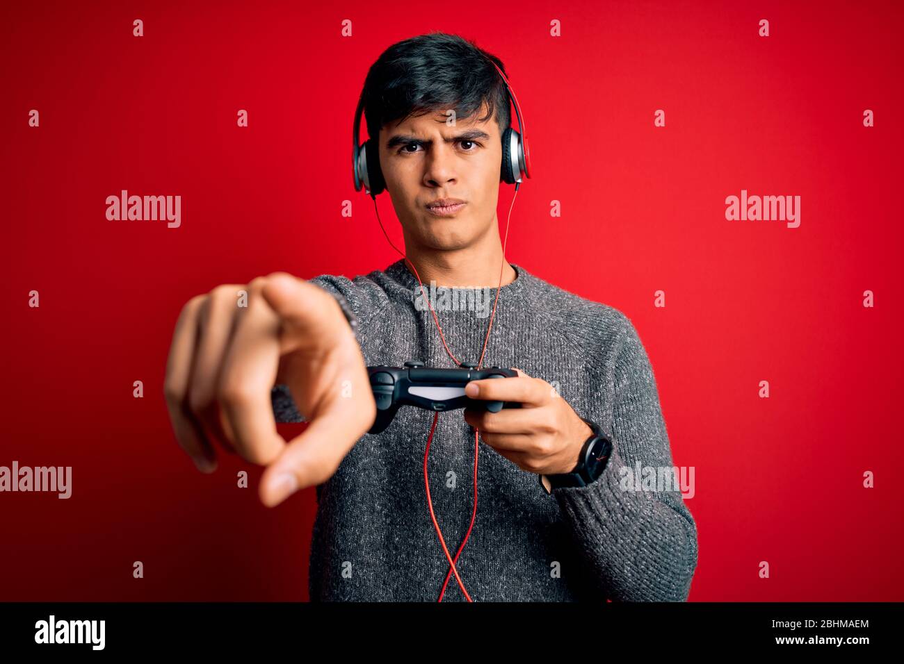 Young handsome gamer man playing video game using joystick and ...