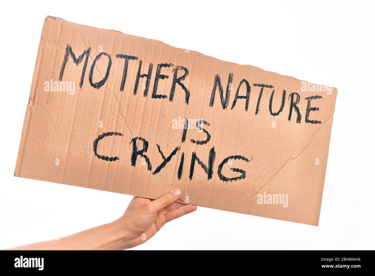 Cardboard banner with MOTHER NATURE IS CRYING text, protesting against ...