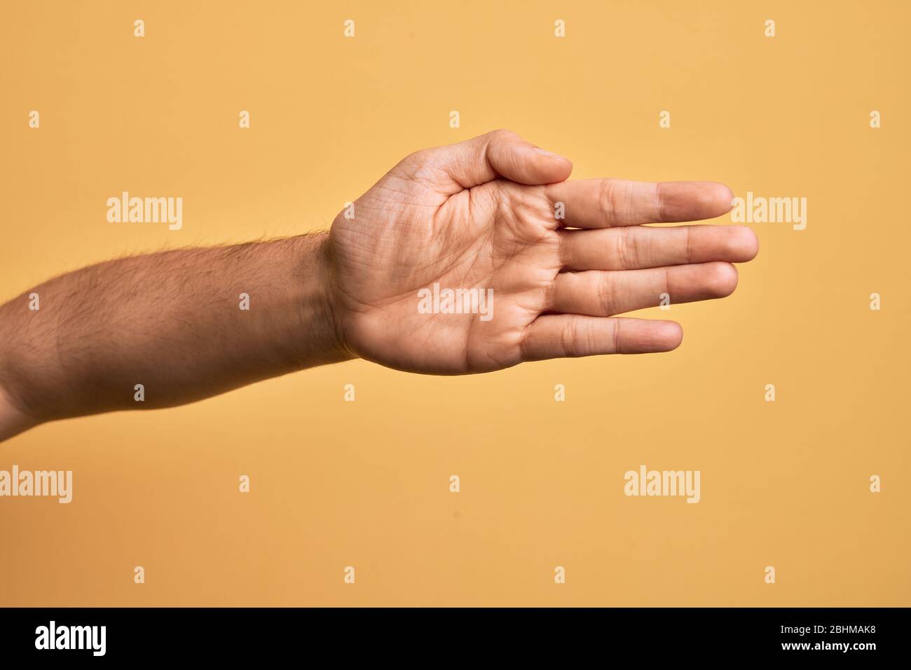 Hand of caucasian young man showing fingers over isolated yellow ...