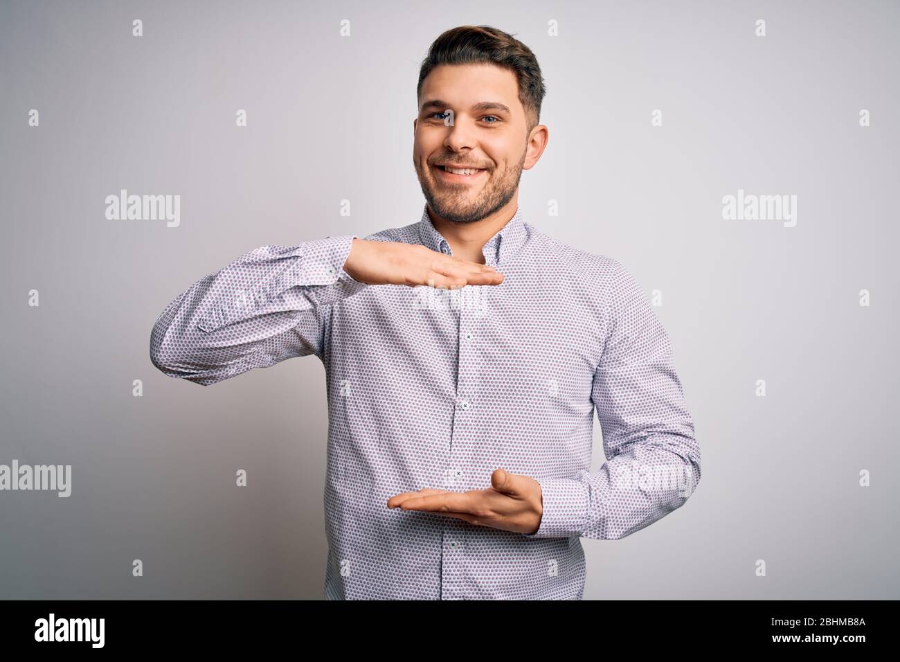 Young business man with blue eyes standing over isolated background ...
