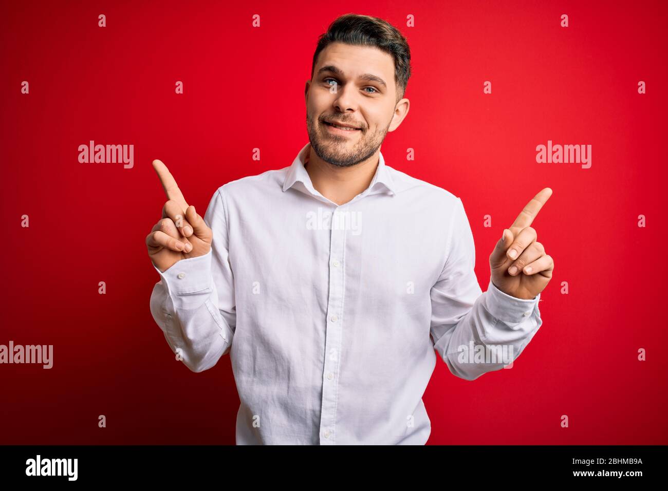 Young business man with blue eyes wearing elegant shirt standing over ...