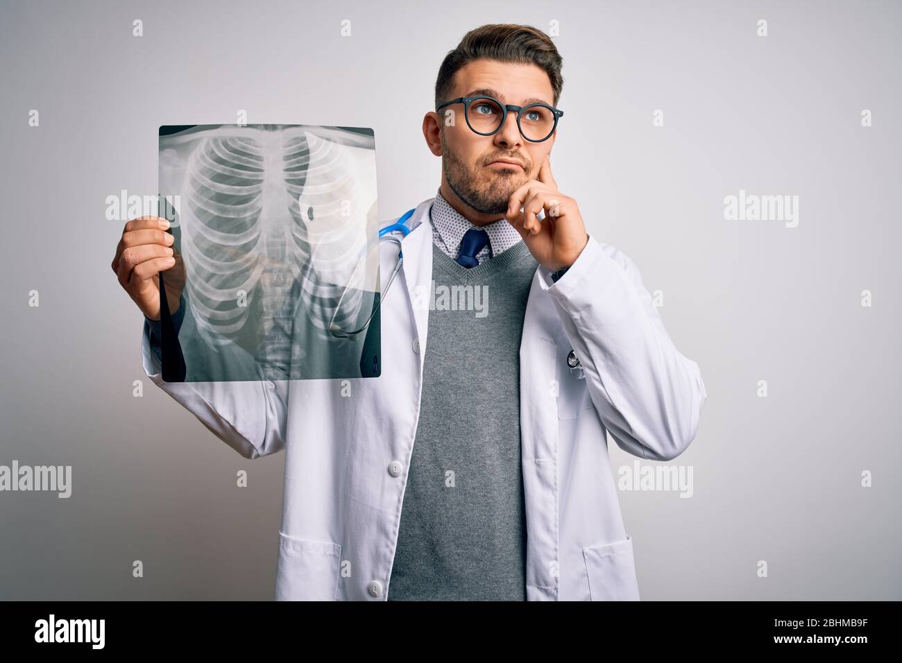 Young doctor man wearing medical coat looking at chest scan radiography ...