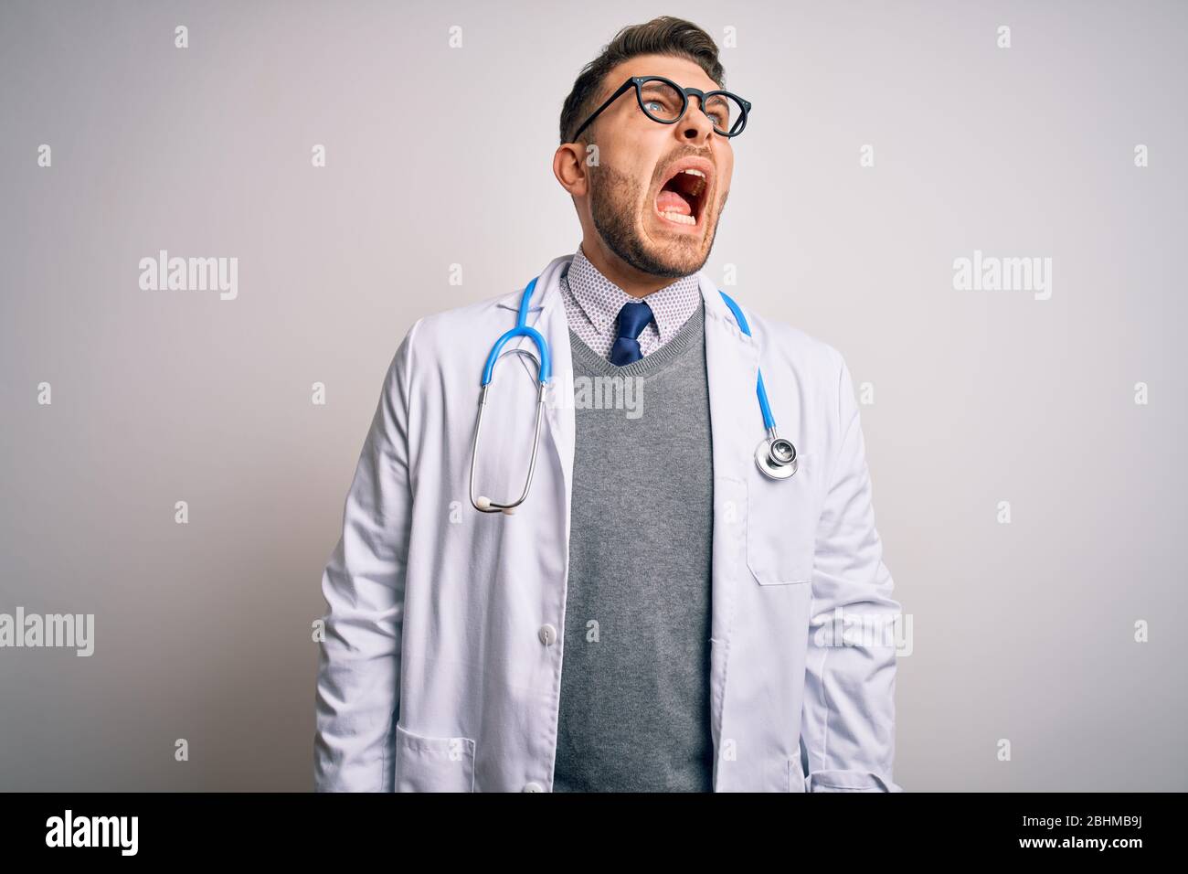 Young doctor man with blue eyes wearing medical coat and stethoscope ...