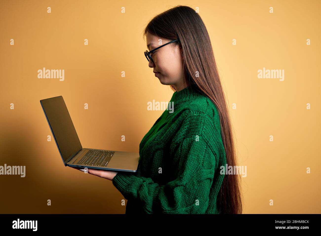 Young asian business woman wearing glasses and working using computer ...