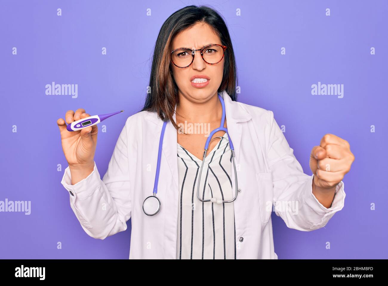 Professional doctor woman showing medical thermometer over purple ...
