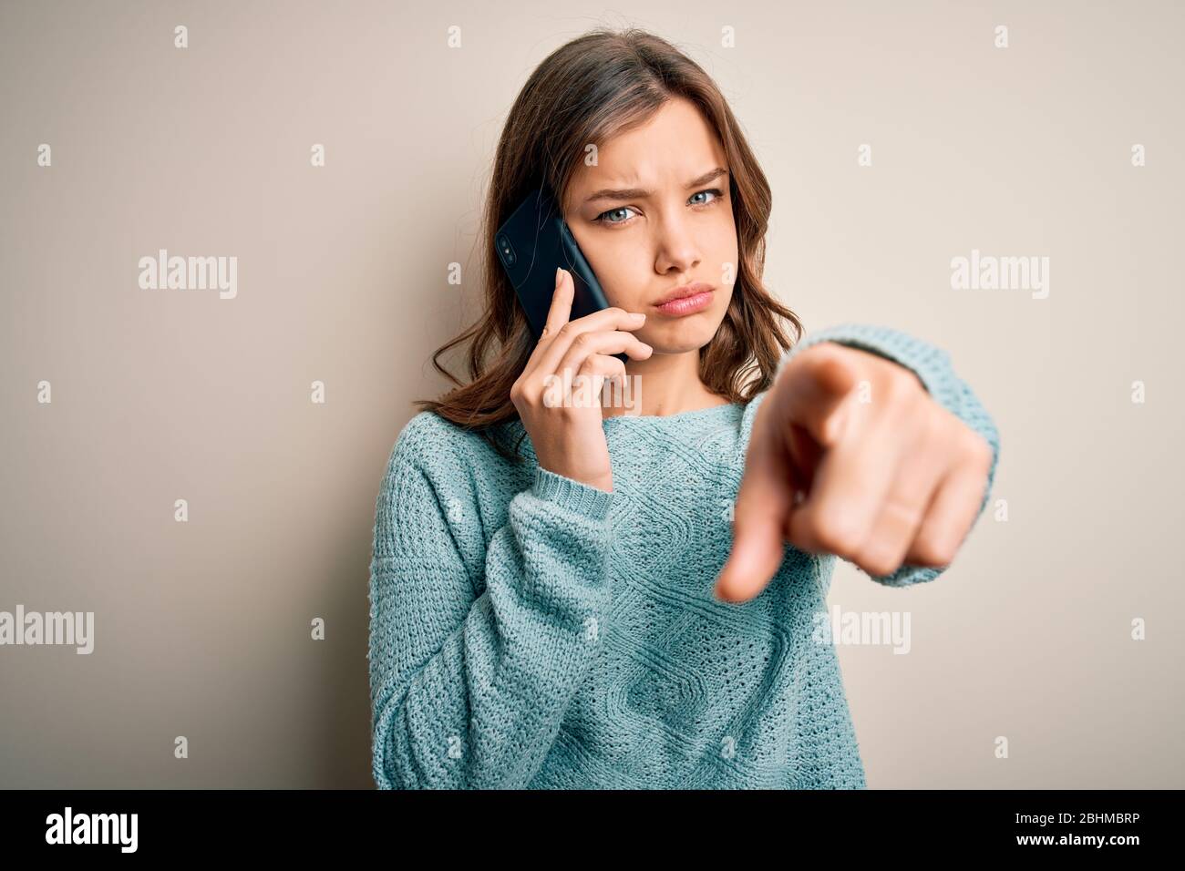 Young blonde girl having a conversation talking on smartphone over ...