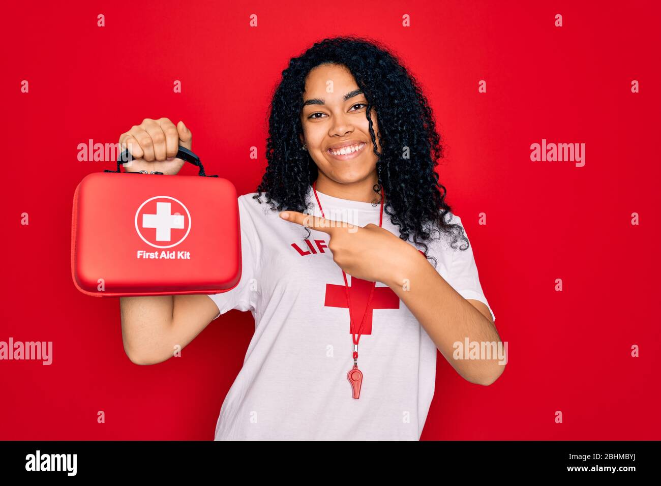 Young african american curly lifeguard woman wearing whistle holding ...