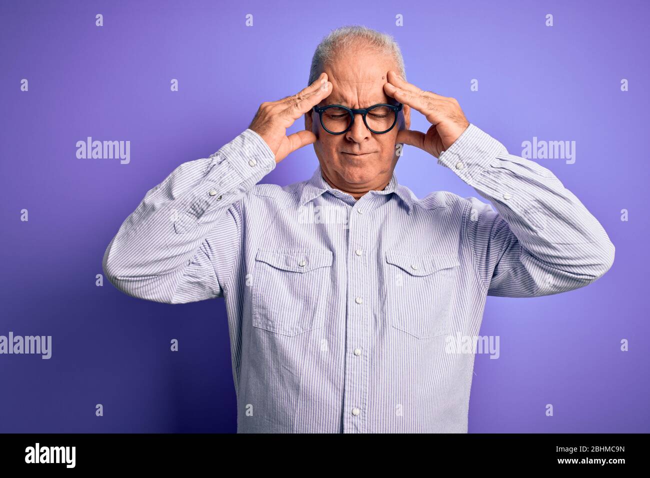 Middle age handsome hoary man wearing striped shirt and glasses over ...