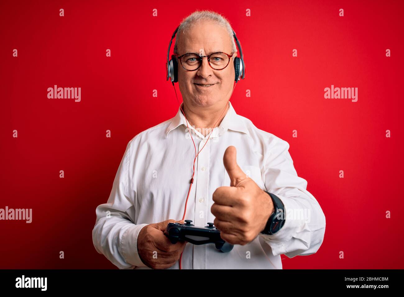Middle age handsome hoary gamer man playing video game using joystick ...