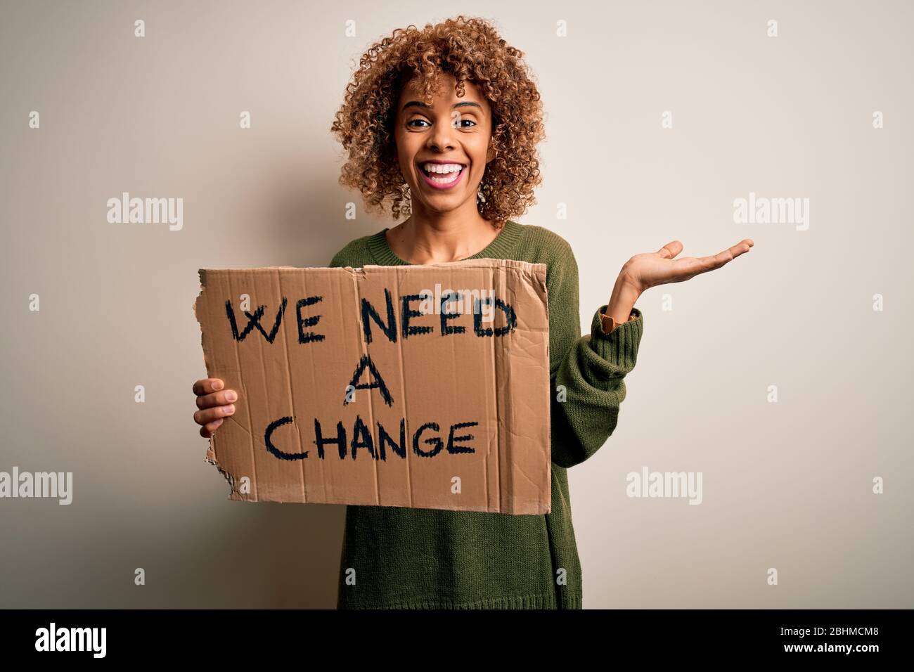 Young african american activist woman asking for change holding banner ...