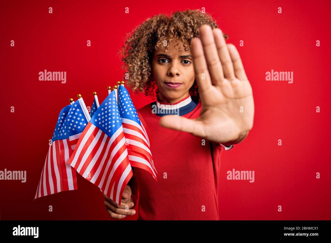 Young african american patriotic curly woman holding united states ...