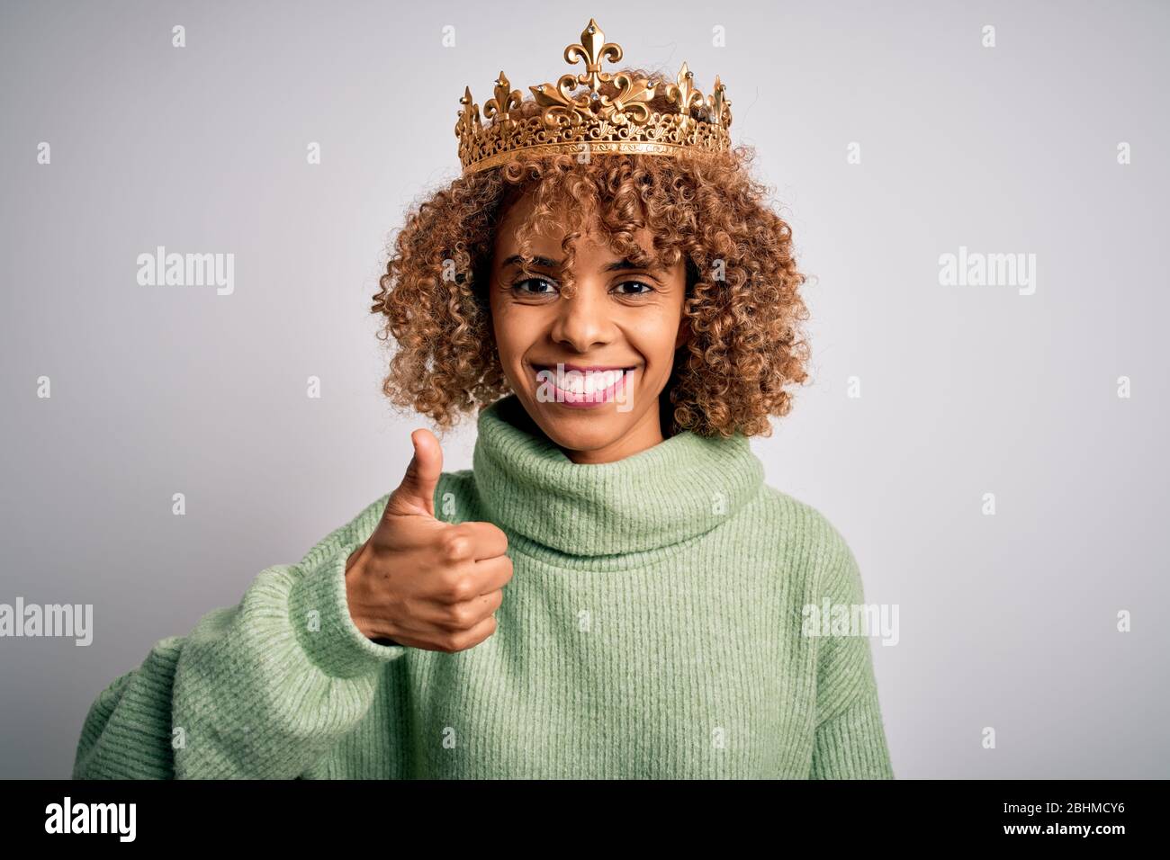 Young african american woman wearing golden crown of queen over ...