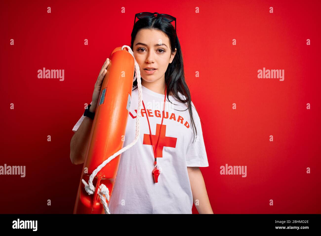 Young lifeguard woman wearing secury guard equipent holding rescue ...