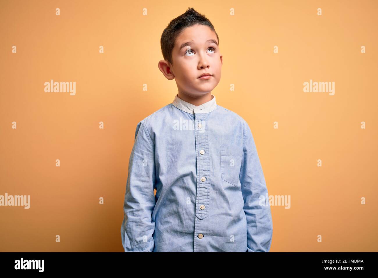 Young little boy kid wearing elegant shirt standing over yellow ...