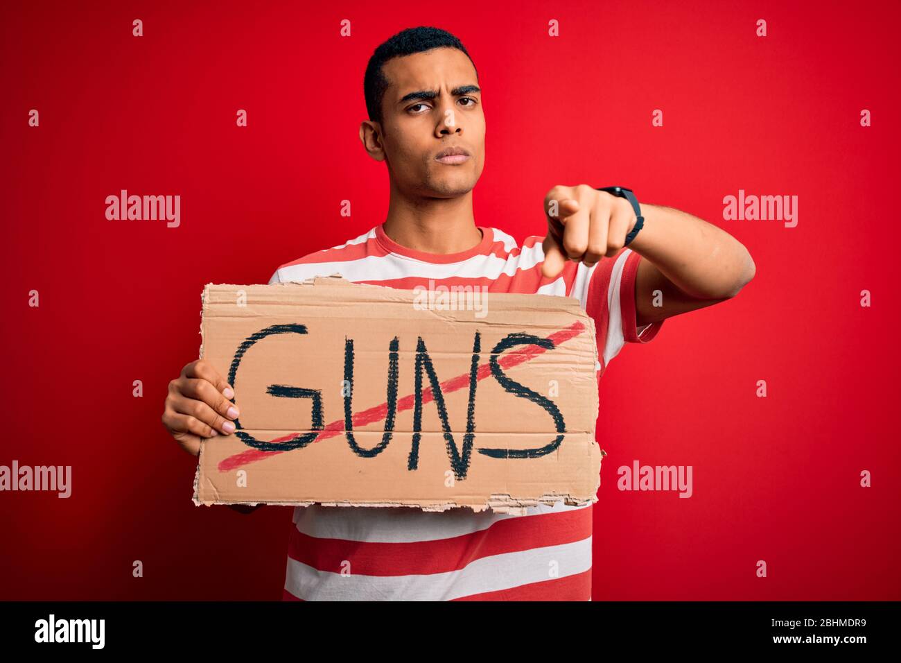 Young handsome african american man holding banner with prohibited guns ...