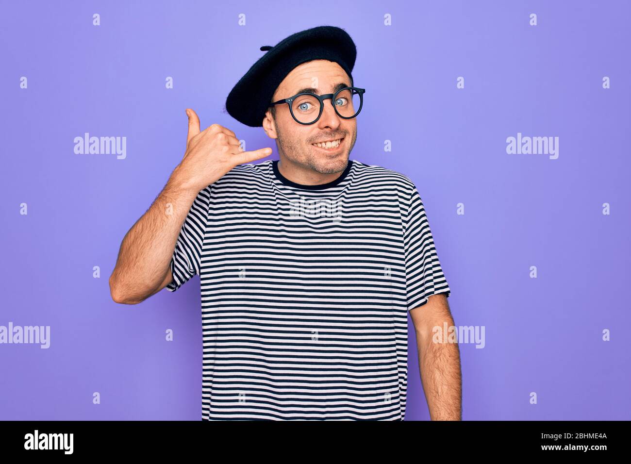 Handsome man with blue eyes wearing striped t-shirt and french beret ...