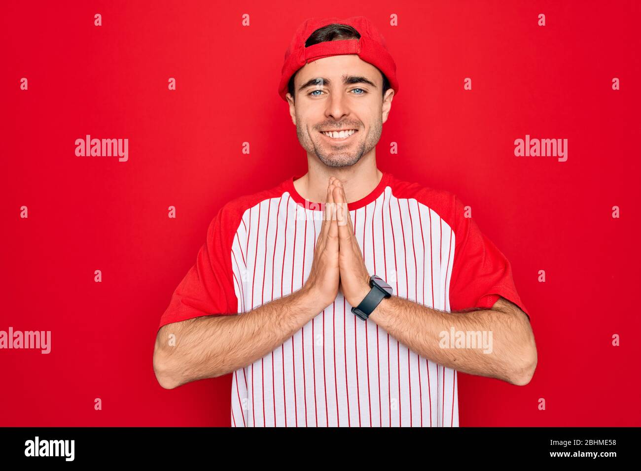 Young handsome sporty man with blue eyes wearing striped baseball t ...