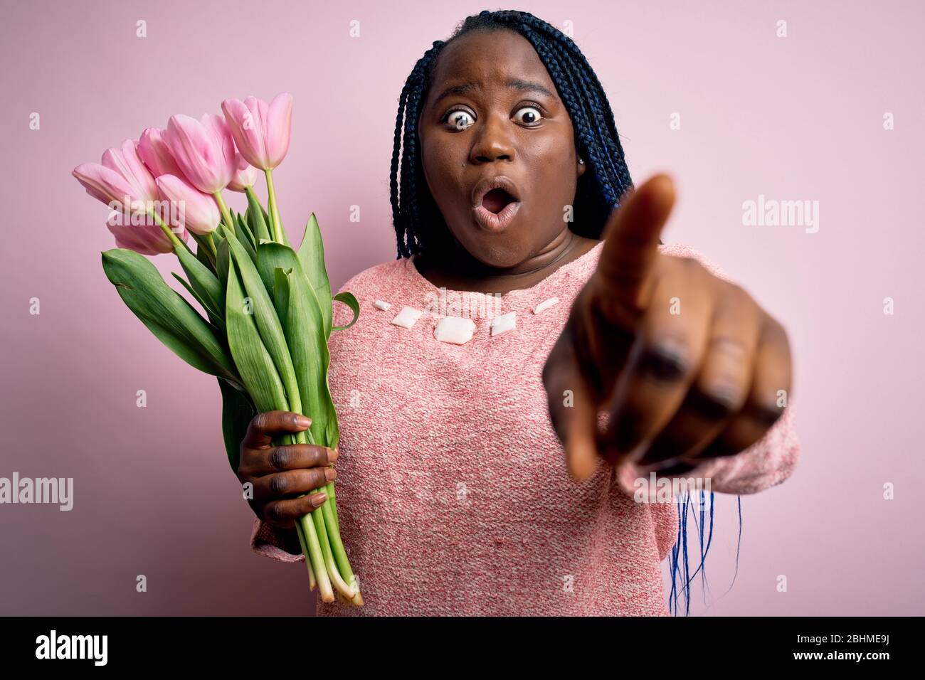 Young african american plus size woman with braids holding bouquet of ...