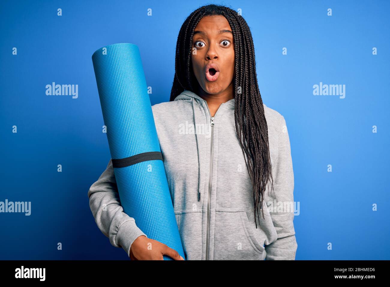 Young african american fitness woman holding yoga mat over isolated ...