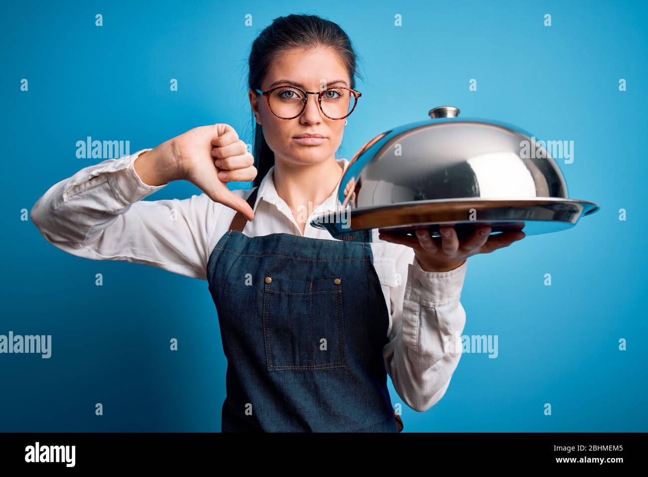 Young beautiful waitress woman with blue eyes holding tray with dome ...