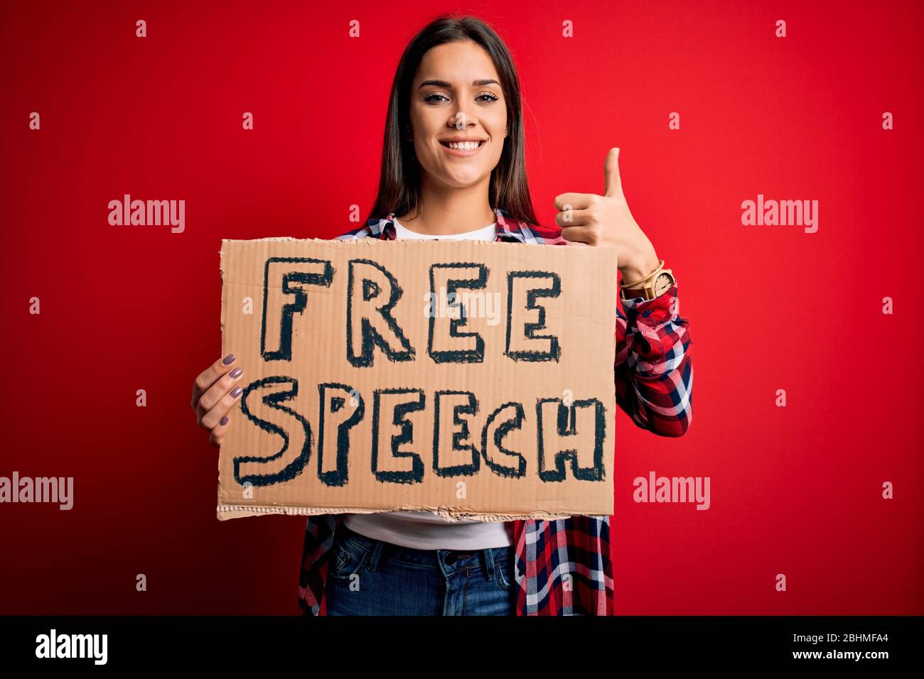 Young beautiful brunette woman asking for rights holding banner with ...