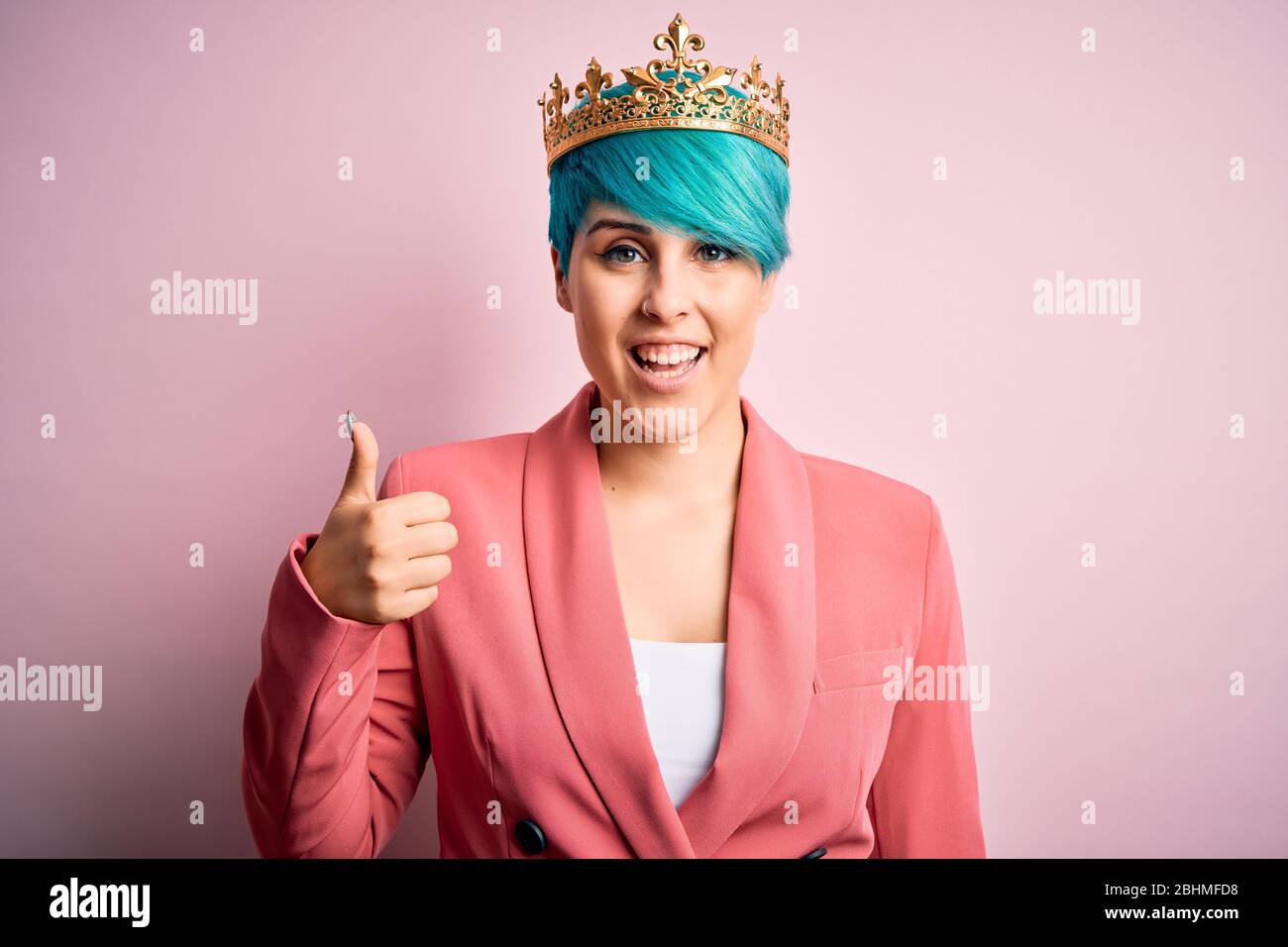 Young business woman with blue fashion hair wearing queen crown over ...