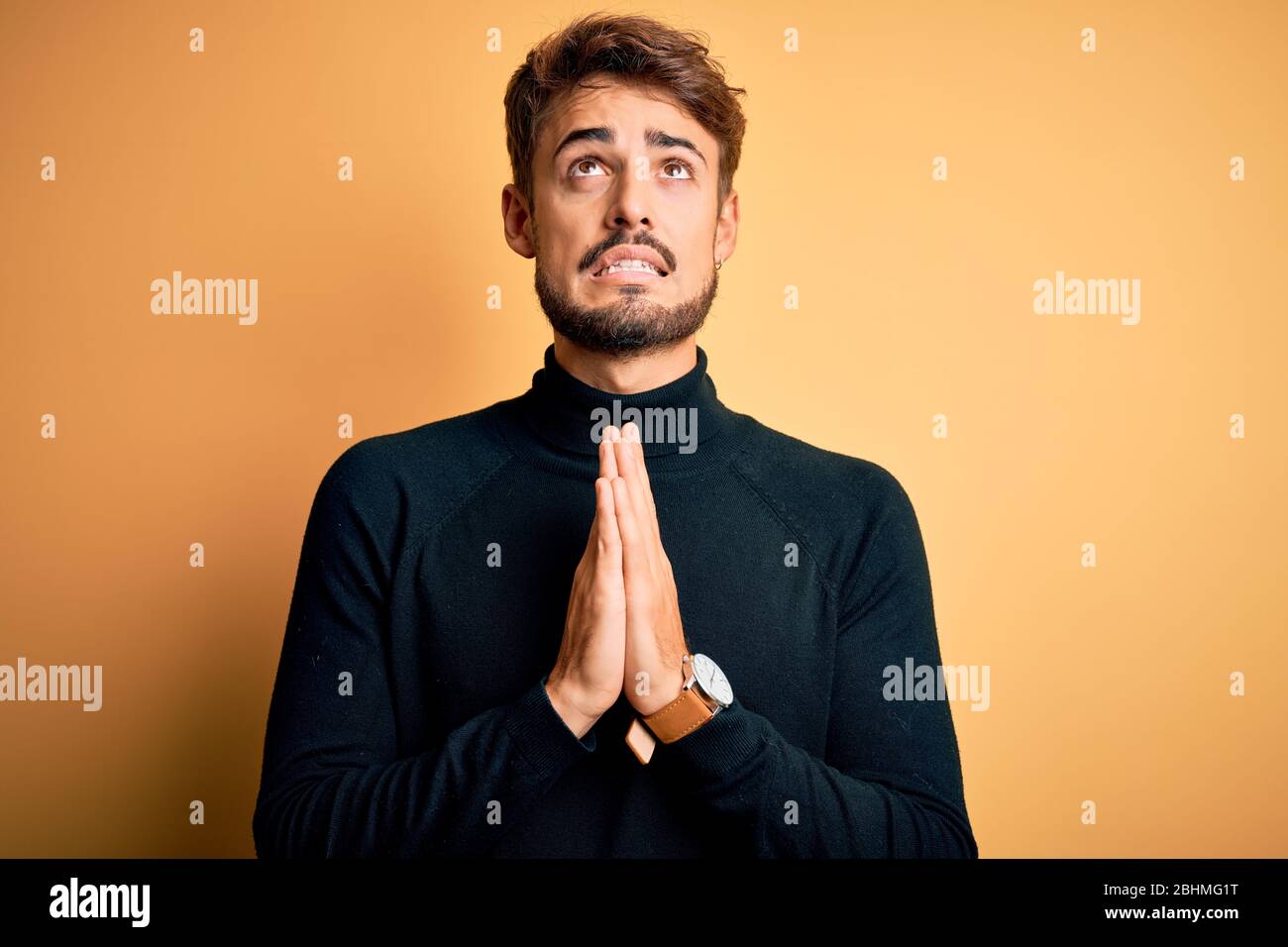 Young handsome man with beard wearing turtleneck sweater standing over ...