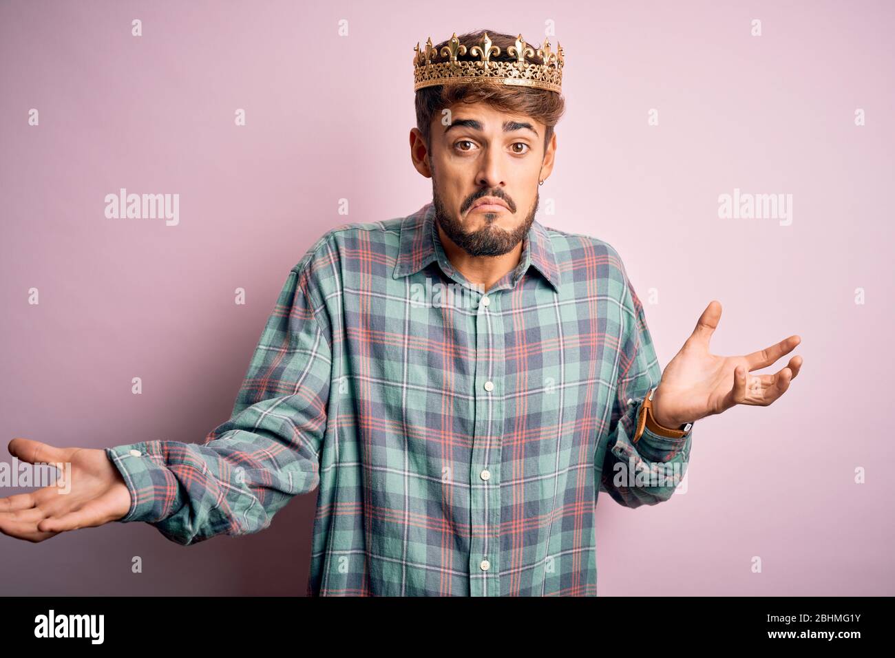 Young man with beard wearing golden crown of king standing over ...