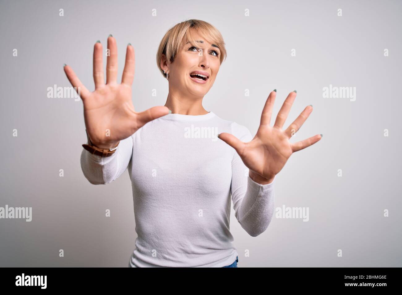 Young beautiful blonde woman with modern short hair hairstyle standing ...