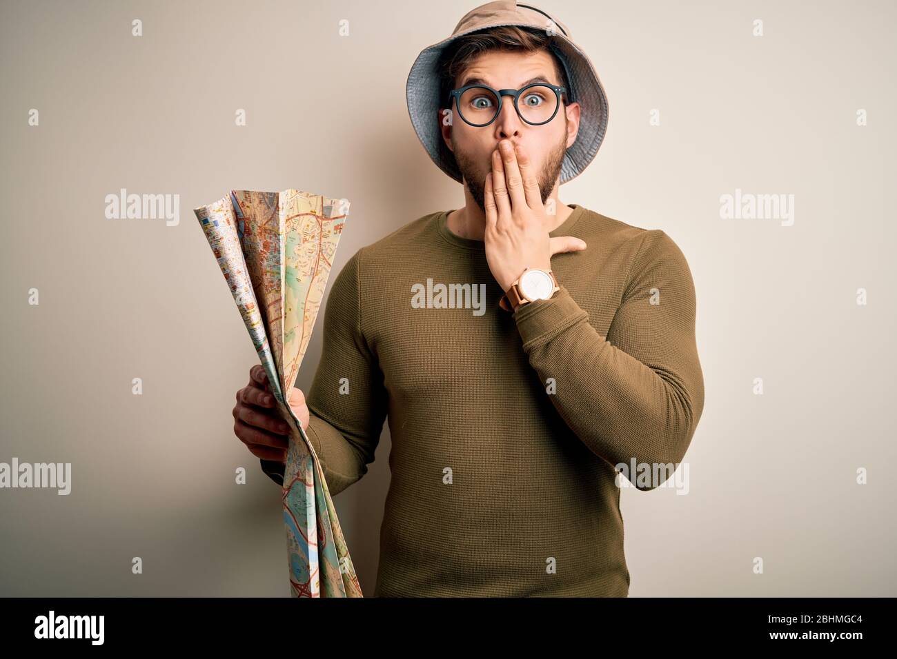 Young blond explorer man with beard and blue eyes wearing glasses and ...