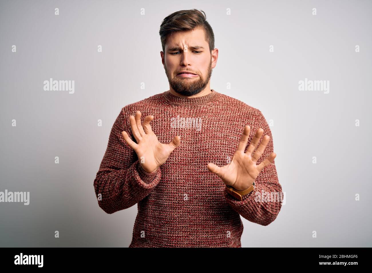 Young blond man with beard and blue eyes wearing casual sweater over ...
