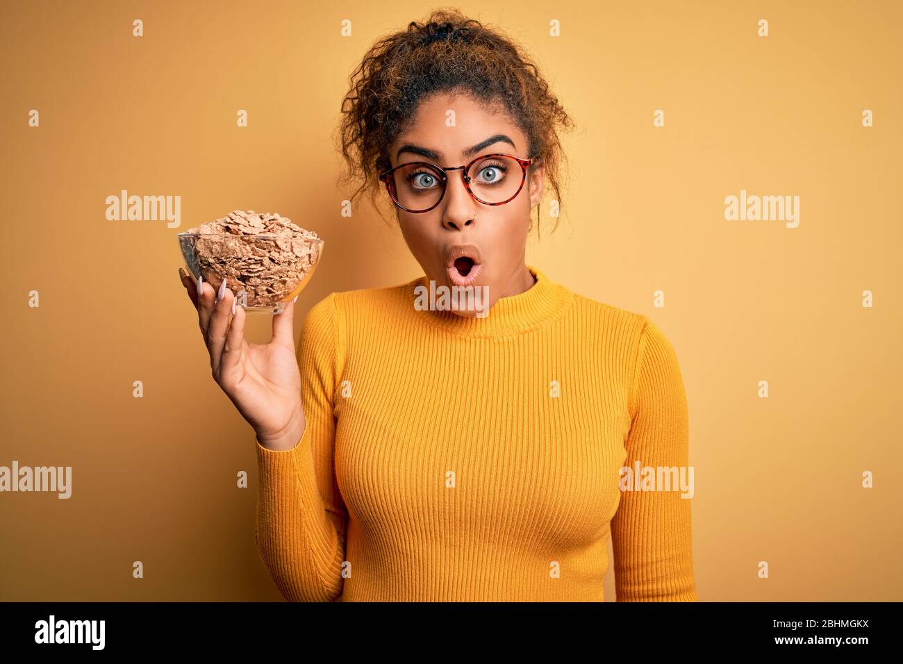 Young african american girl holding bowl with healthy cornflakes ...