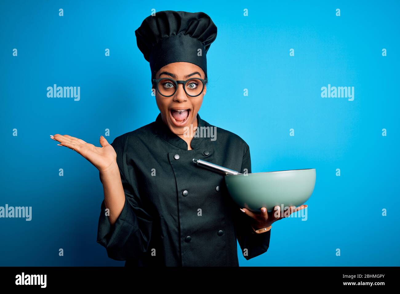 Young african american chef girl wearing cooker uniform and hat using ...
