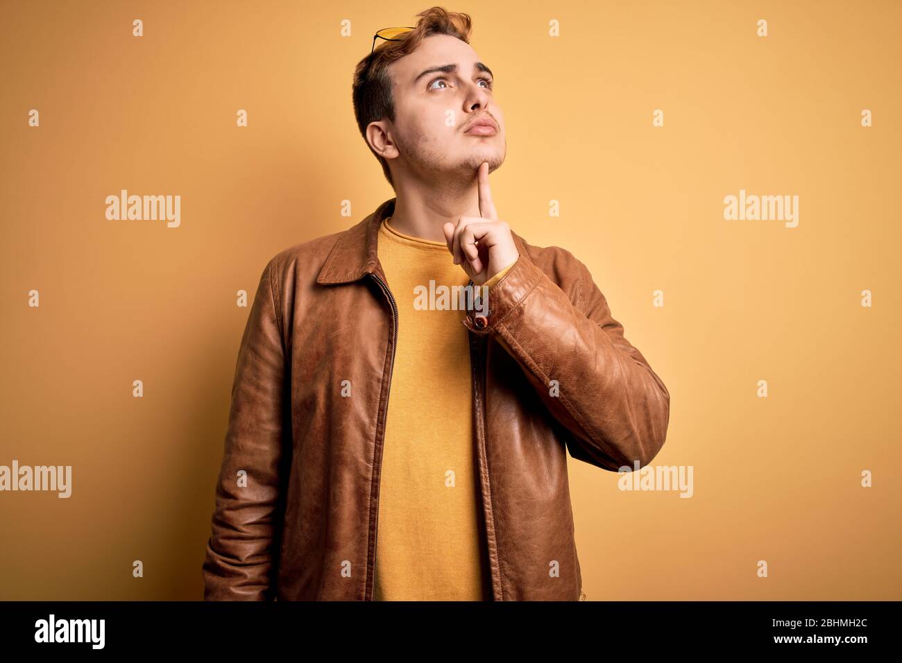 Young handsome redhead man wearing casual leather jacket over isolated ...