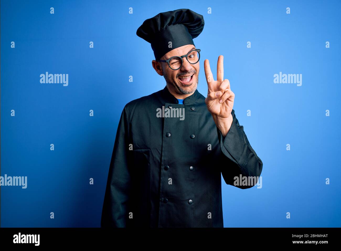 Young handsome chef man wearing cooker uniform and hat over isolated ...