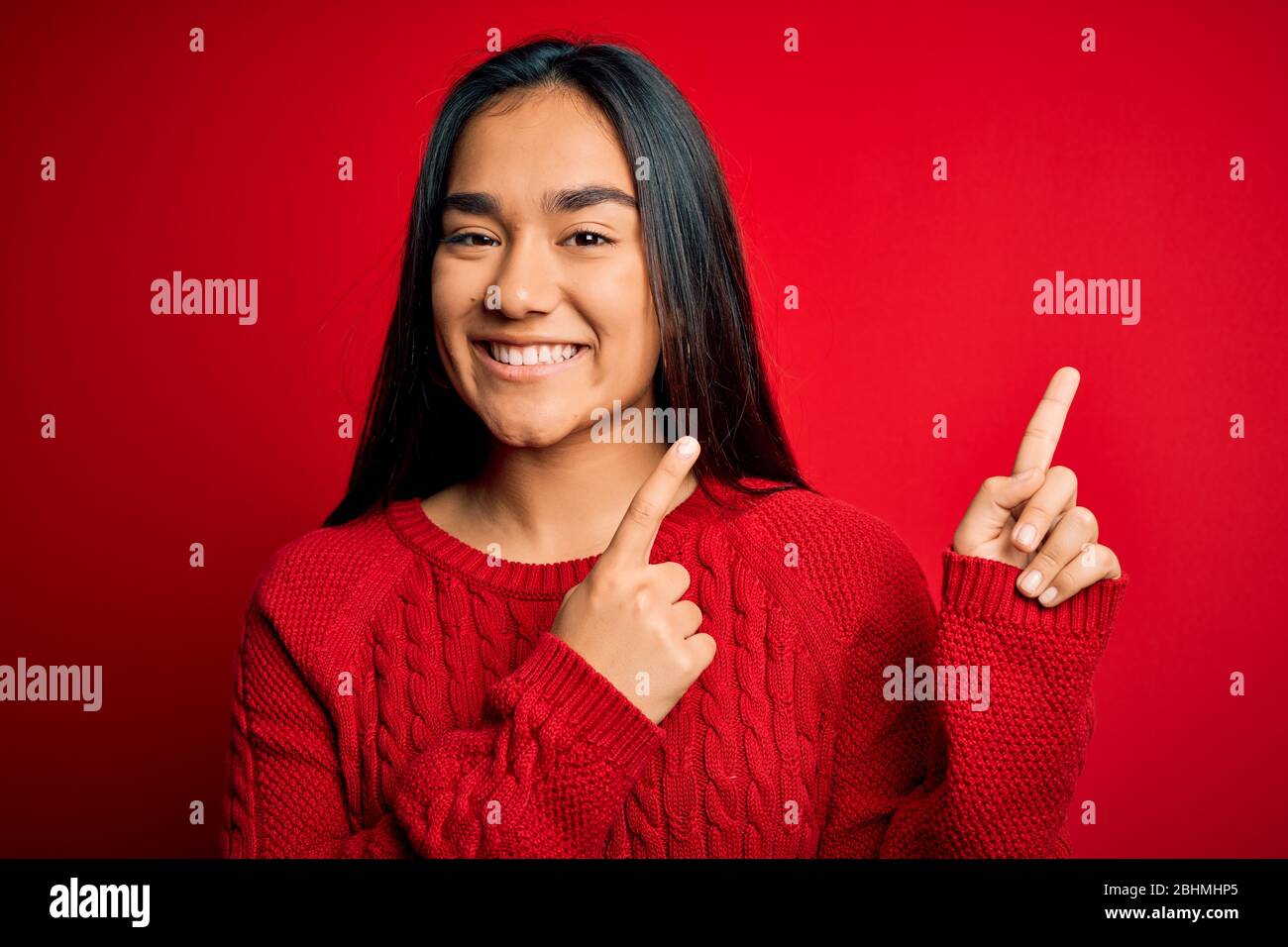 Young beautiful asian woman wearing casual sweater standing over ...
